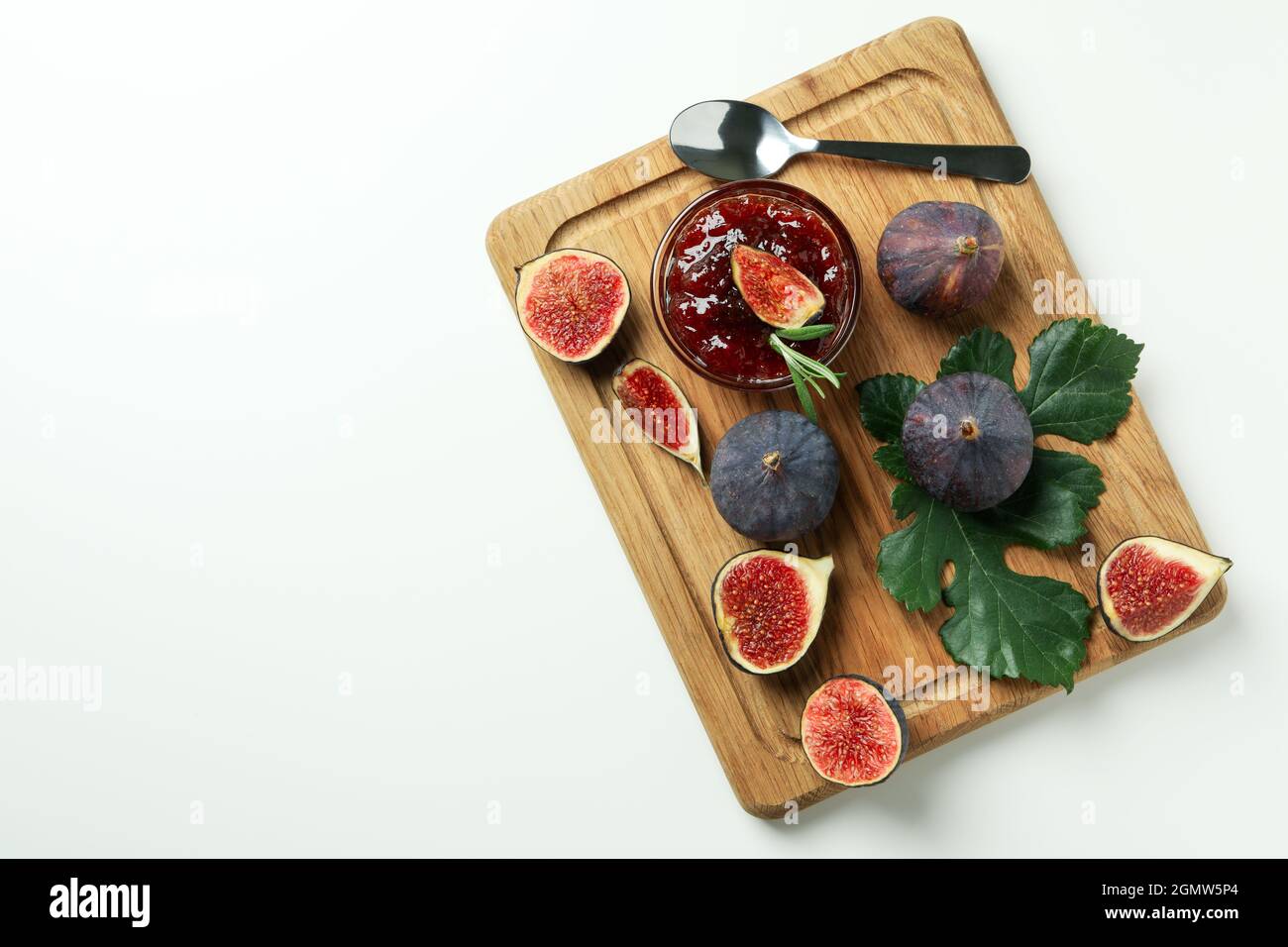 Board with fig jam, ingredients and spoon on white background Stock ...