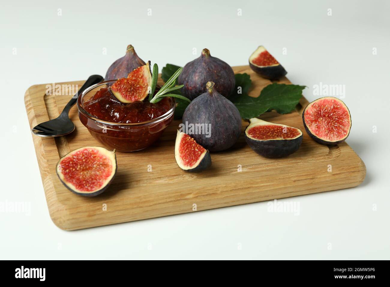 Board with fig jam, ingredients and spoon on white background Stock ...