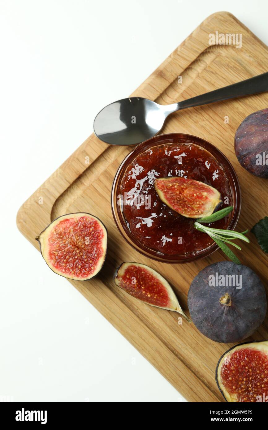 Board with fig jam, ingredients and spoon on white background Stock ...