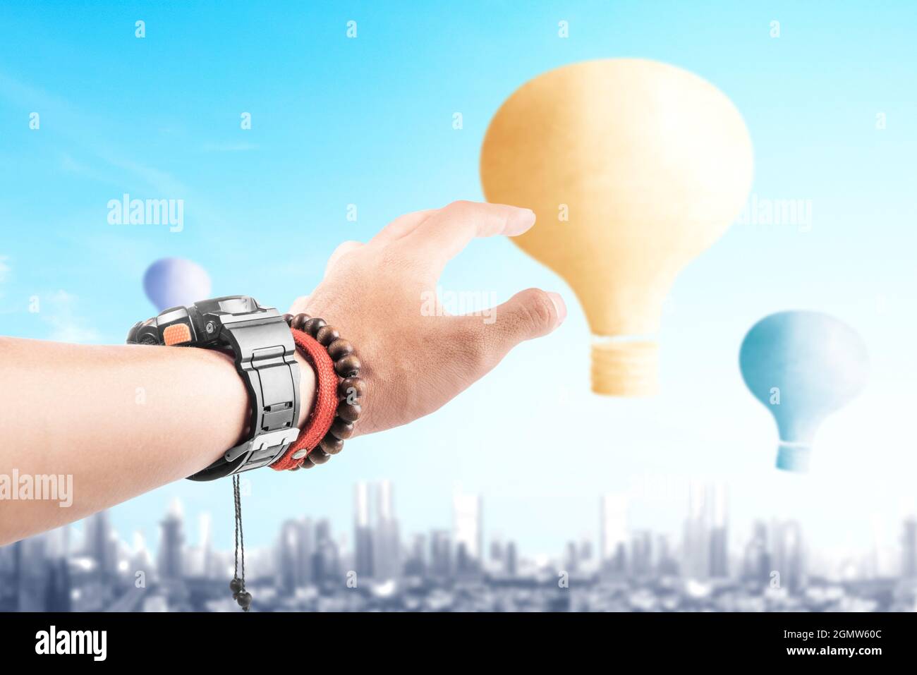 Human hand with colorful air balloon flying with cityscape background ...