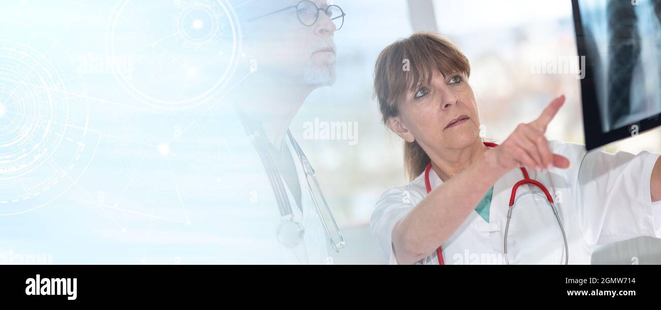 Two doctors examining x-ray report in medical office; panoramic banner ...