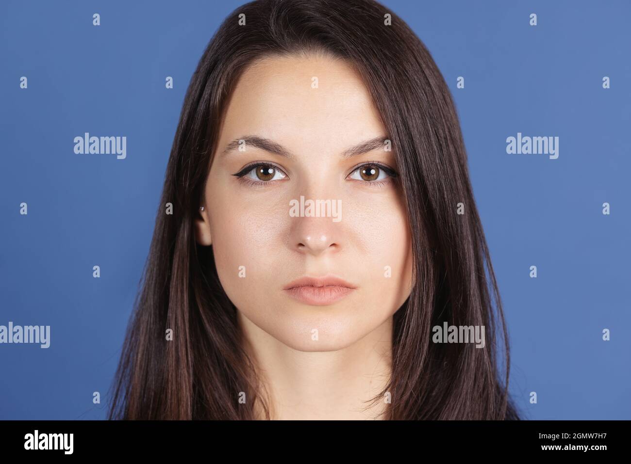 Close-up portrait of beautiful woman seriously looking at camera ...