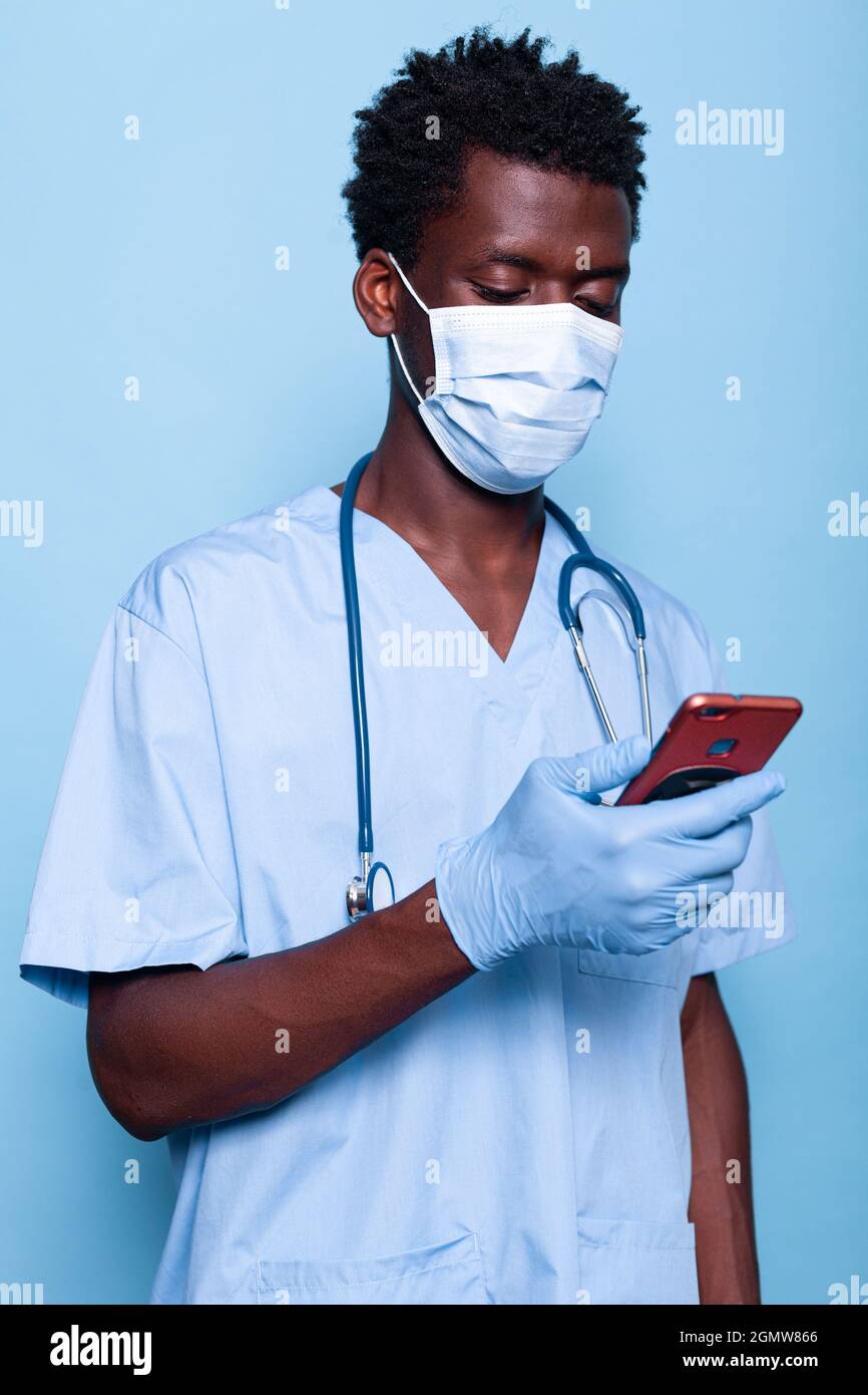 Man working as nurse looking at smartphone in hand. Healthcare ...