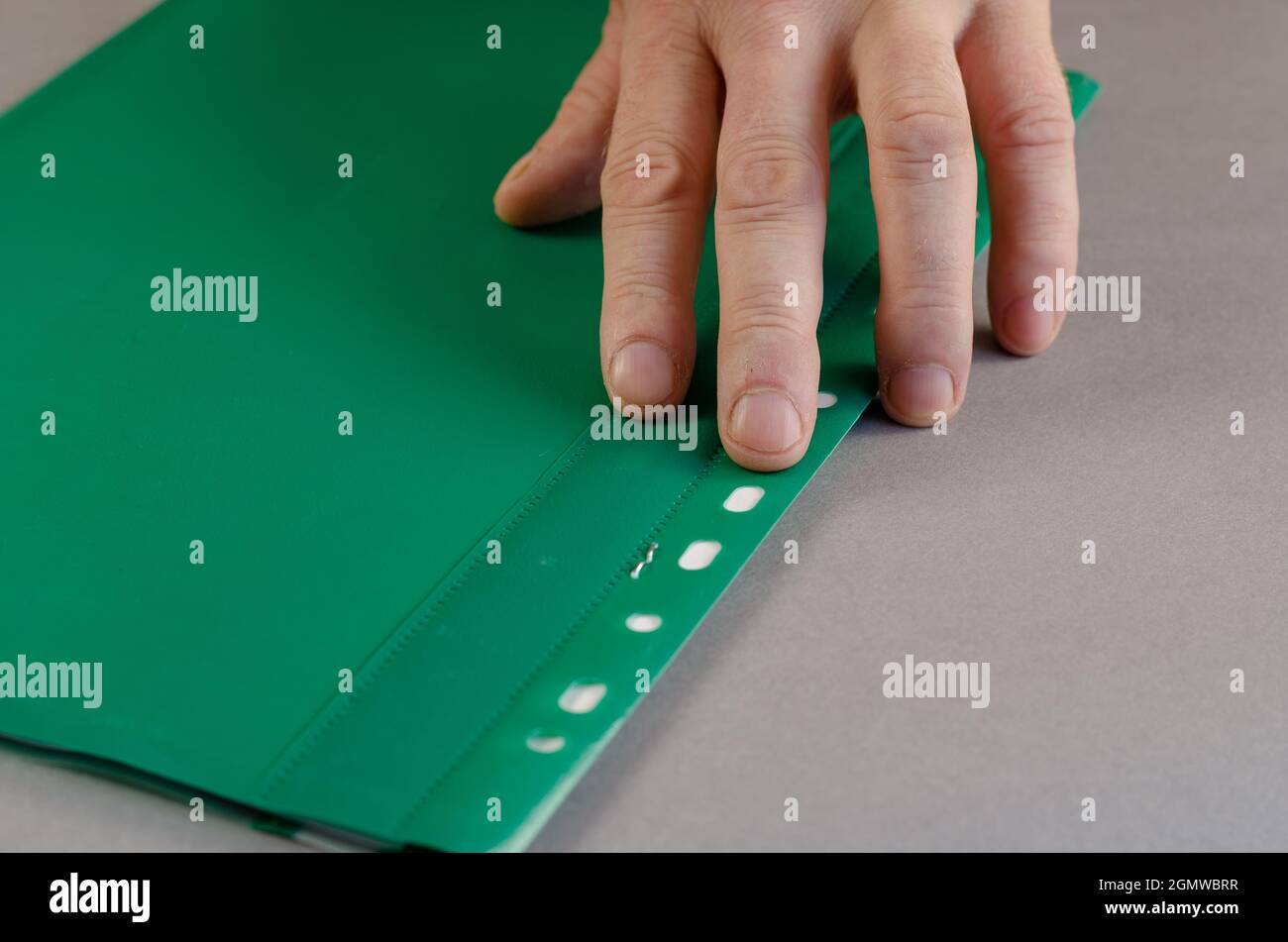 Mature male hand lies on top of green file folder. Person presse Stock ...