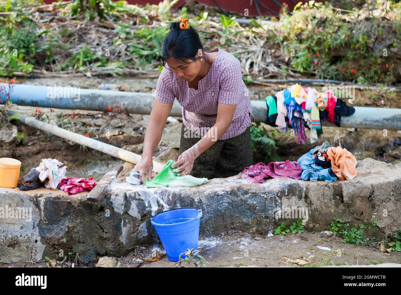 Woman washing clothes in bucket hi-res stock photography and images - Alamy