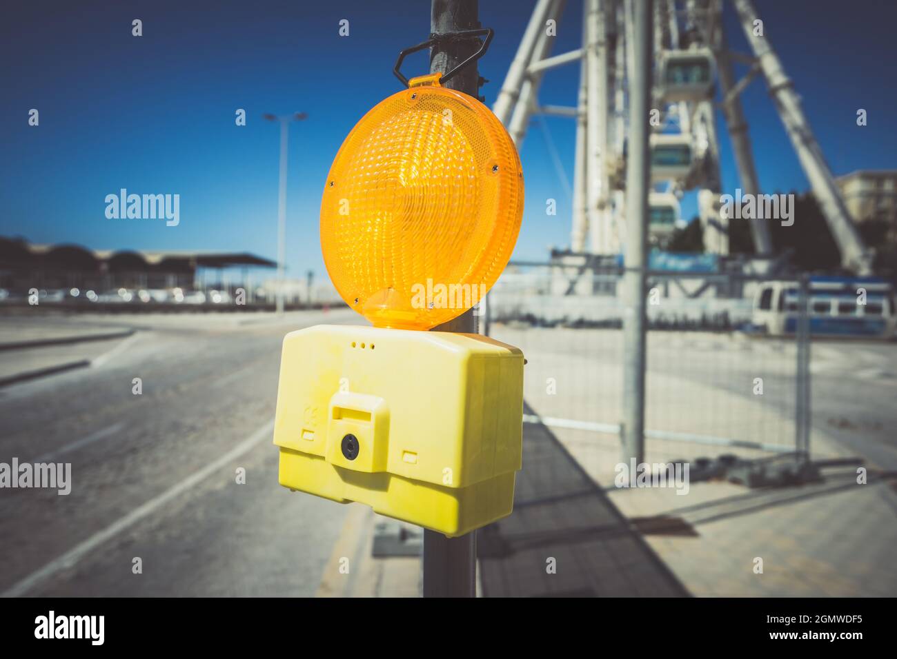 Yellow warning signal lamp attached on a pole outdoors at a ...