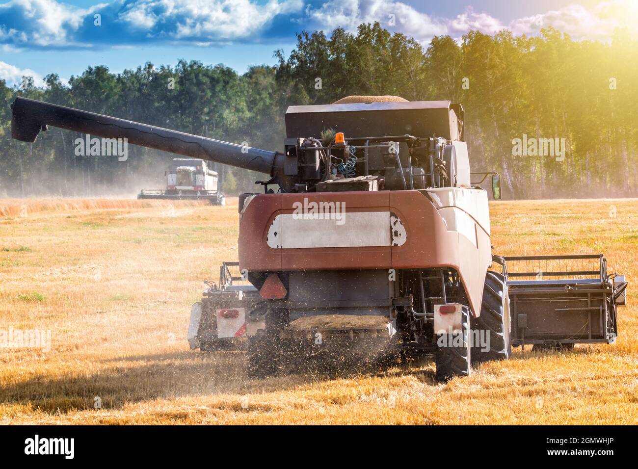 Modern combine harvesters working in the field on a clear sunny day ...