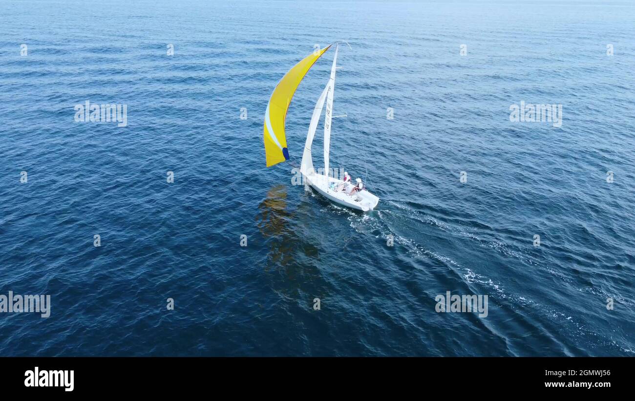 Sea regatta. A beautiful white yacht with a yellow sail sails in the ...