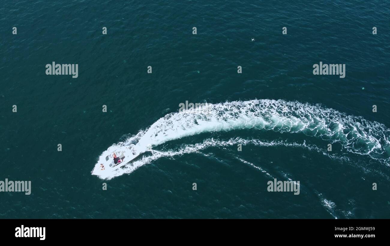 Aerial view of a speedboat moving in a circle for a turn, with a man ...