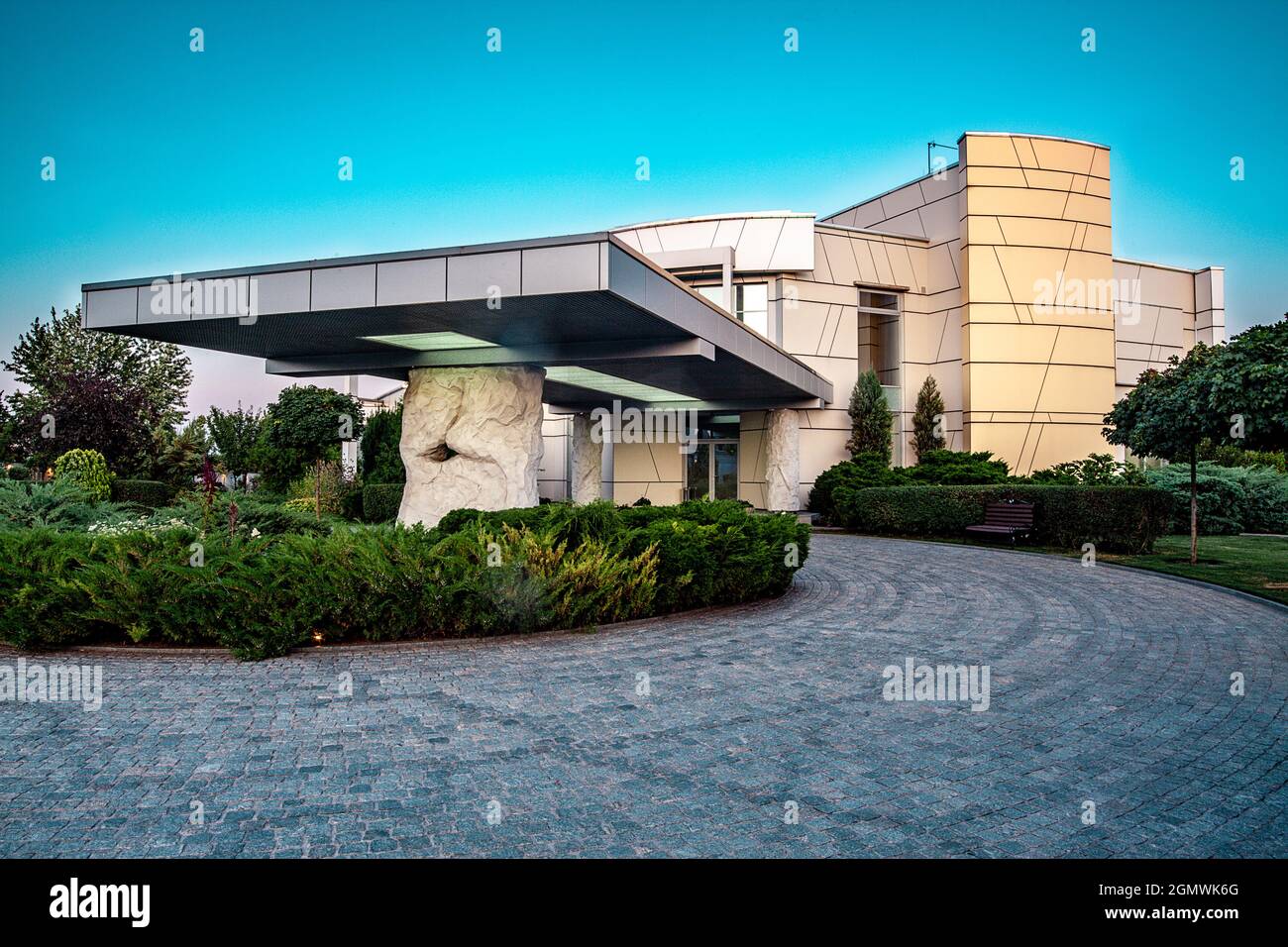 Main entrance of luxurious hotel with porch supported by rocky columns ...