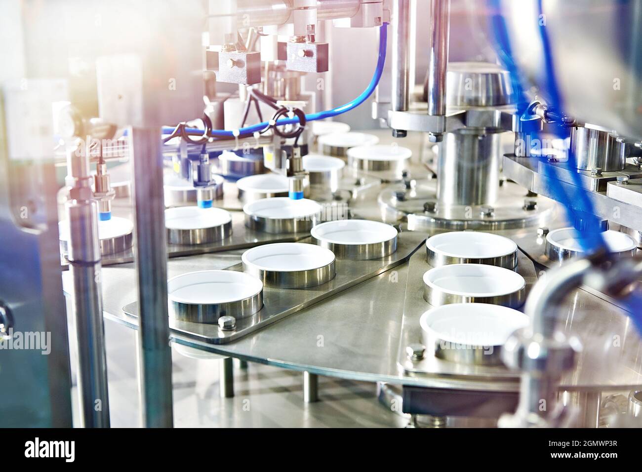 Conveyor at food factory for packing plastic containers Stock Photo - Alamy