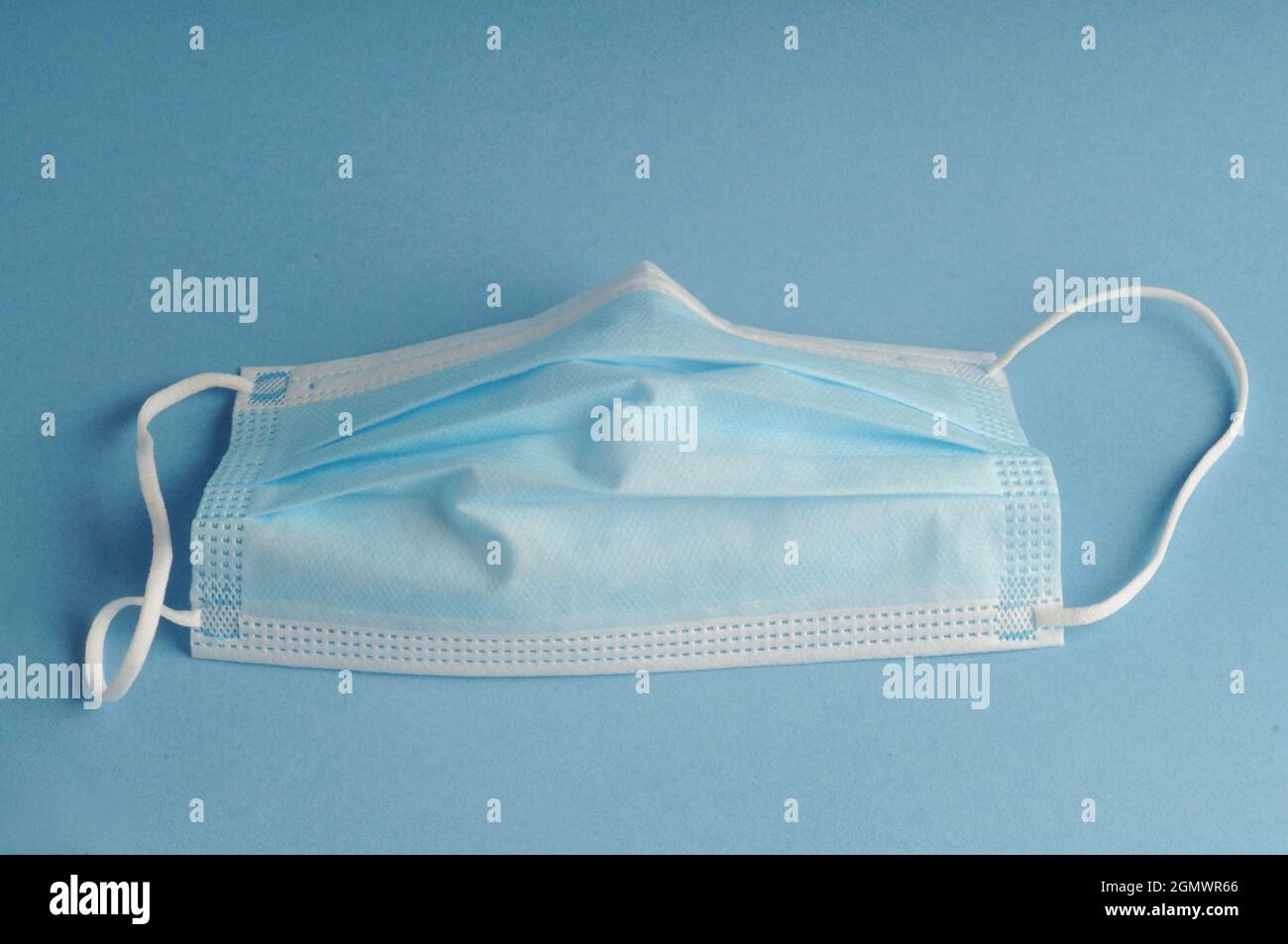standard blue face medical mask on a blue background. Self protection ...