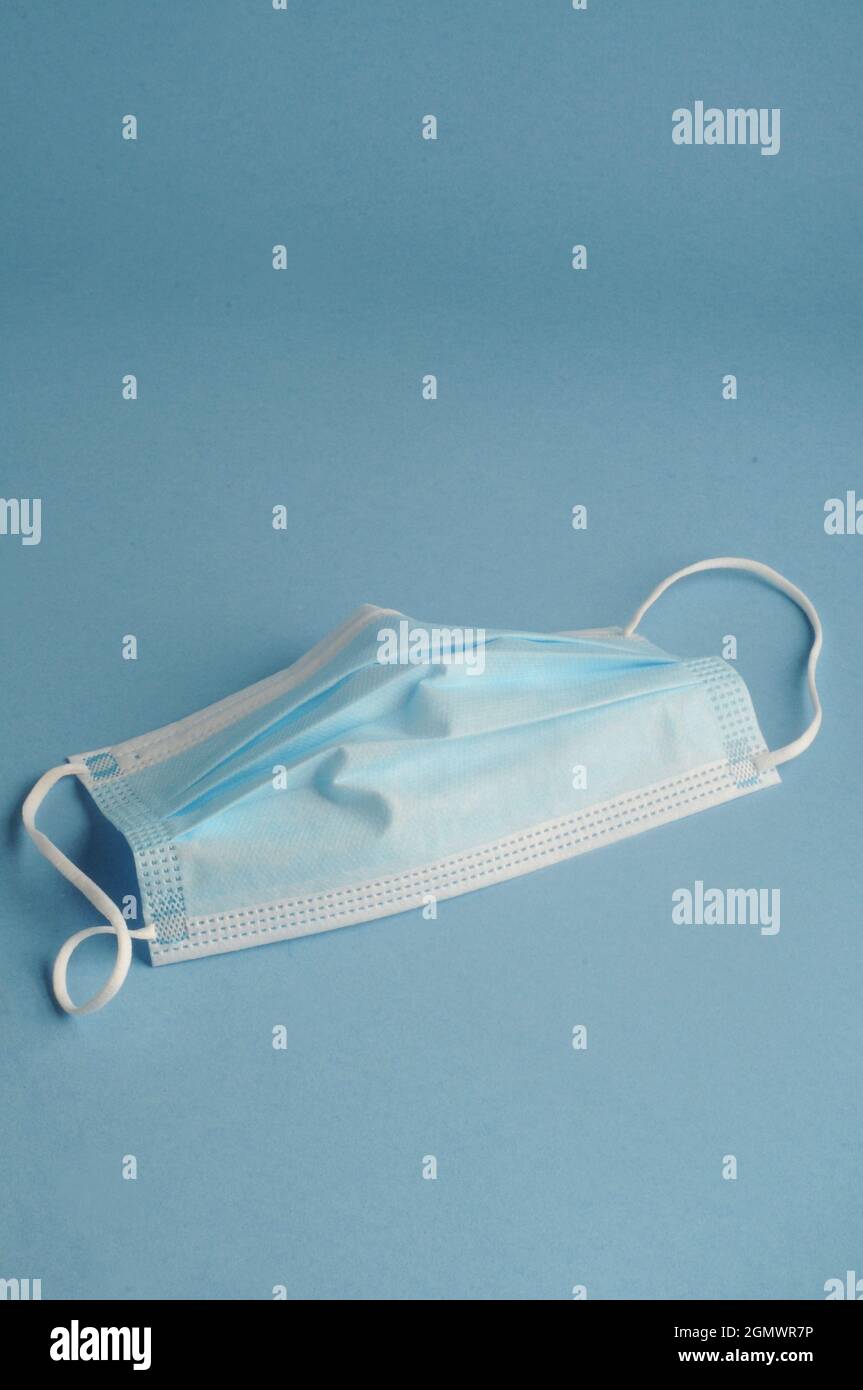 standard blue face medical mask on a blue background. Self protection ...