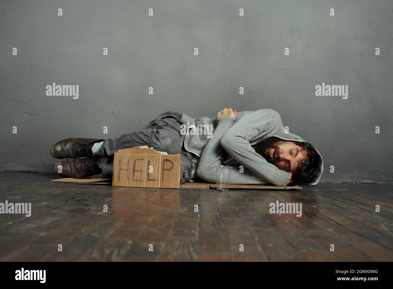 homeless man lying on the floor with a sign help homeless depression ...