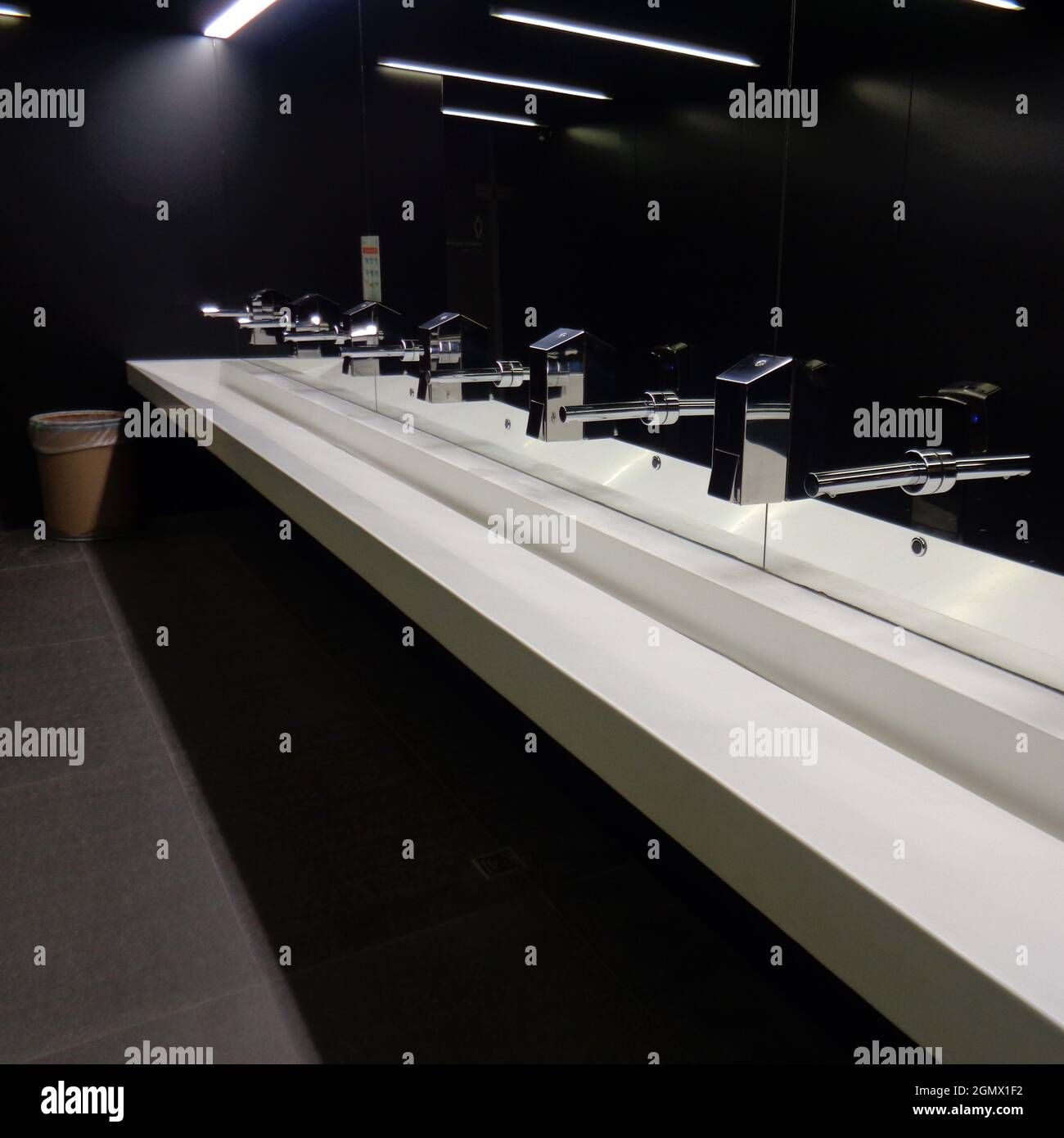 Modern interior of a public toilet sink row Stock Photo - Alamy