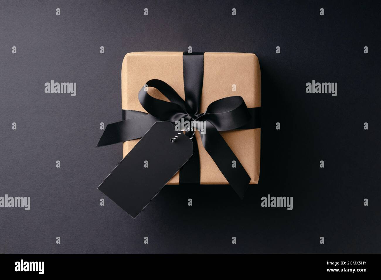 Gift box with black bow and price tag on black background Stock Photo ...