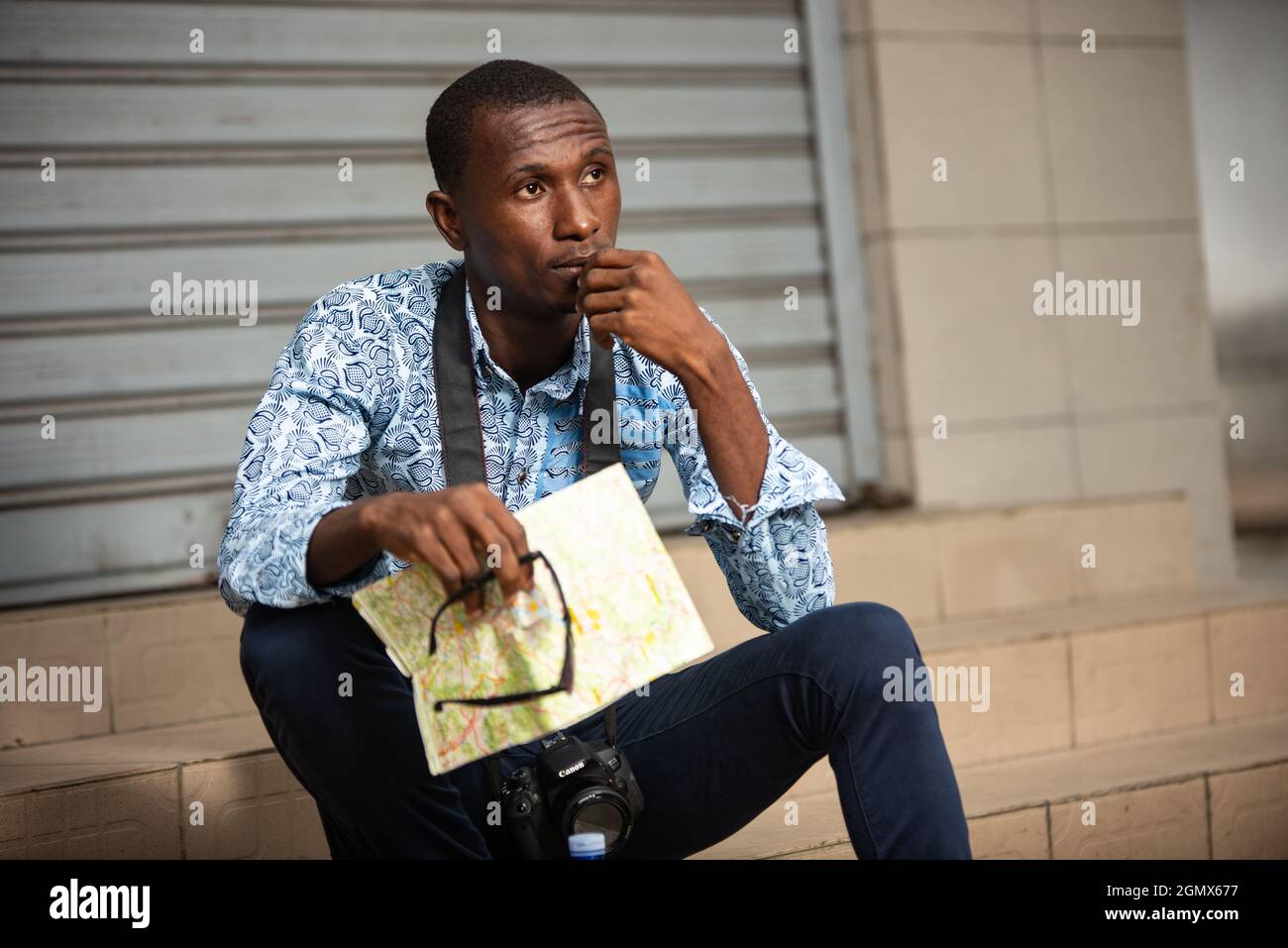 young tourist sitting on stairs thinking about holding a map Stock ...