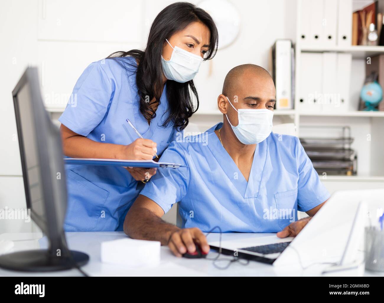 Doctor giving instructions to the secretary in the office Stock Photo ...