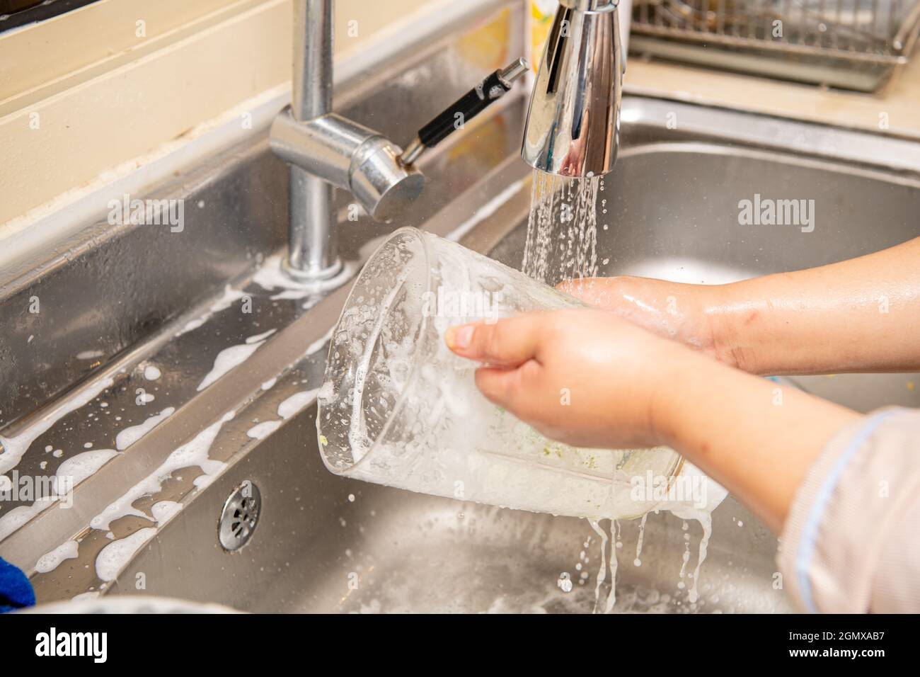 Close up hands of woman washing dishes in kitchen Stock Photo - Alamy