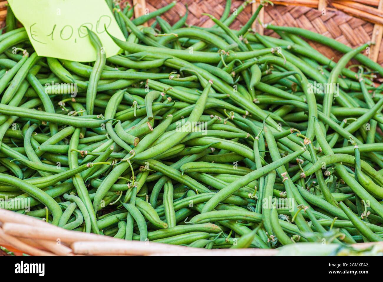 Green beans in a basket in a street food market with price, close up ...