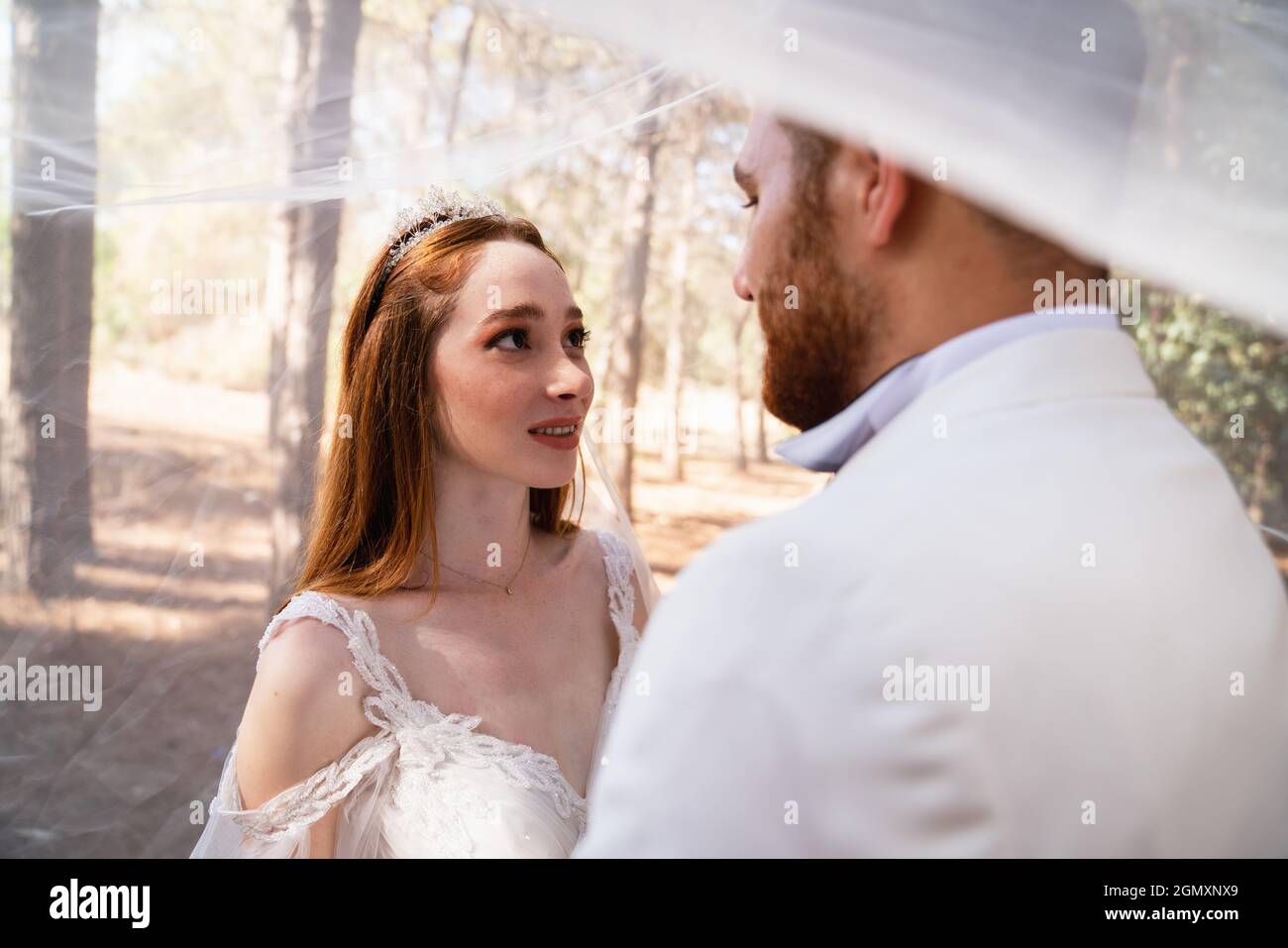 Bride and groom together, and looking eachother with fascinated wide ...
