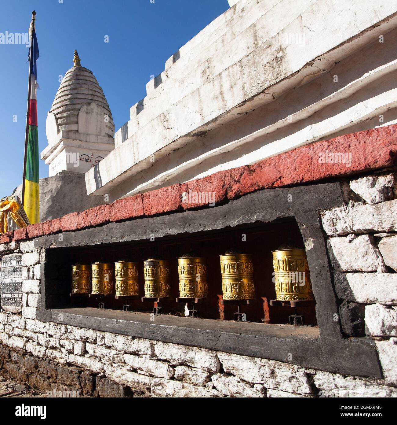 Buddhist stupa or chorten with prayer flags and wheels on the way from ...