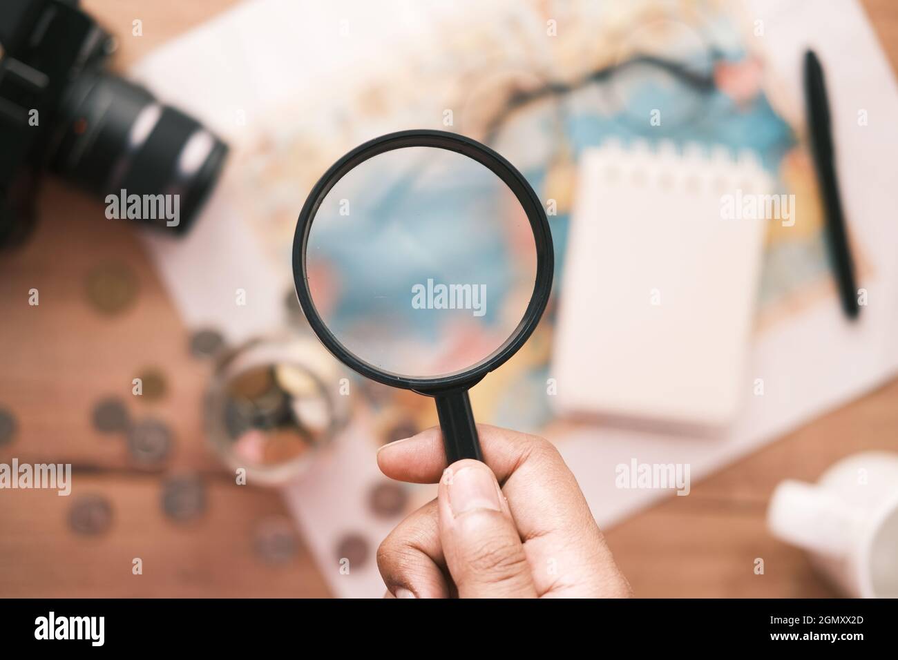 young man using magnifying glass looking something on map Stock Photo ...