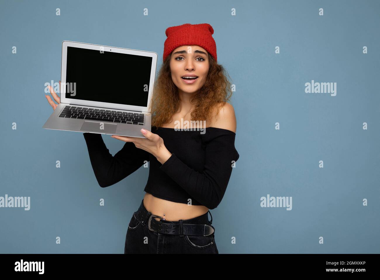 Close-up portrait of beautiful dark blond woman holding laptop computer ...