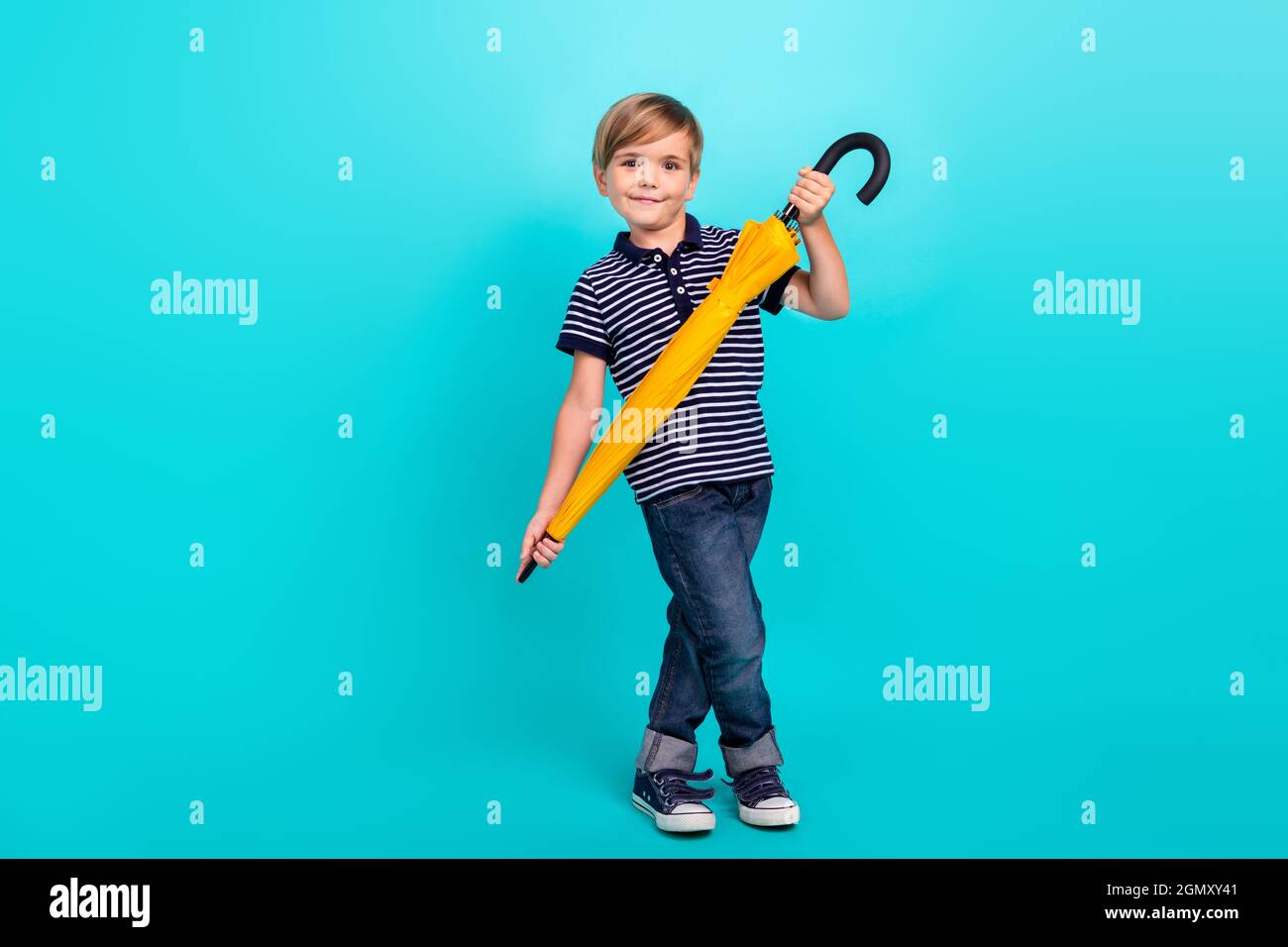 Full length photo of cute small boy hold umbrella wear t-shirt jeans ...