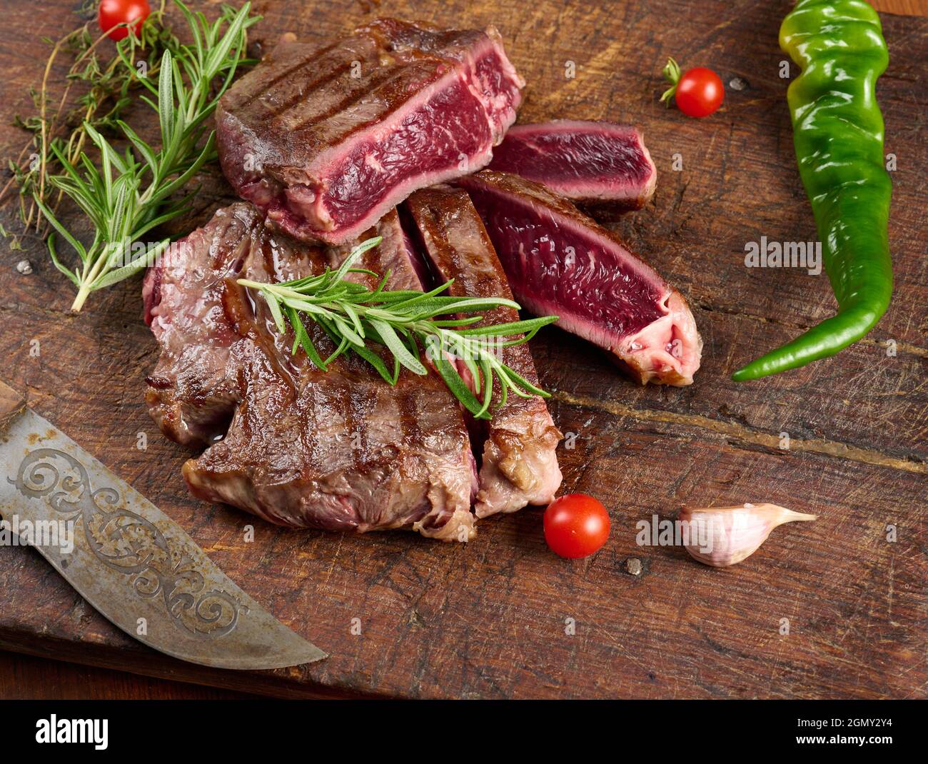 roasted piece of beef ribeye cut into pieces on a vintage brown ...