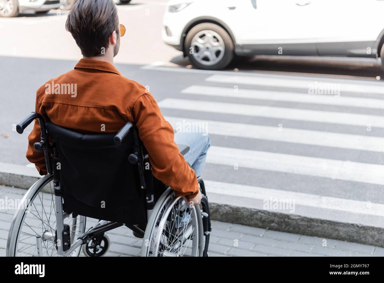 back view of disabled man in wheelchair near border and crosswalk Stock ...