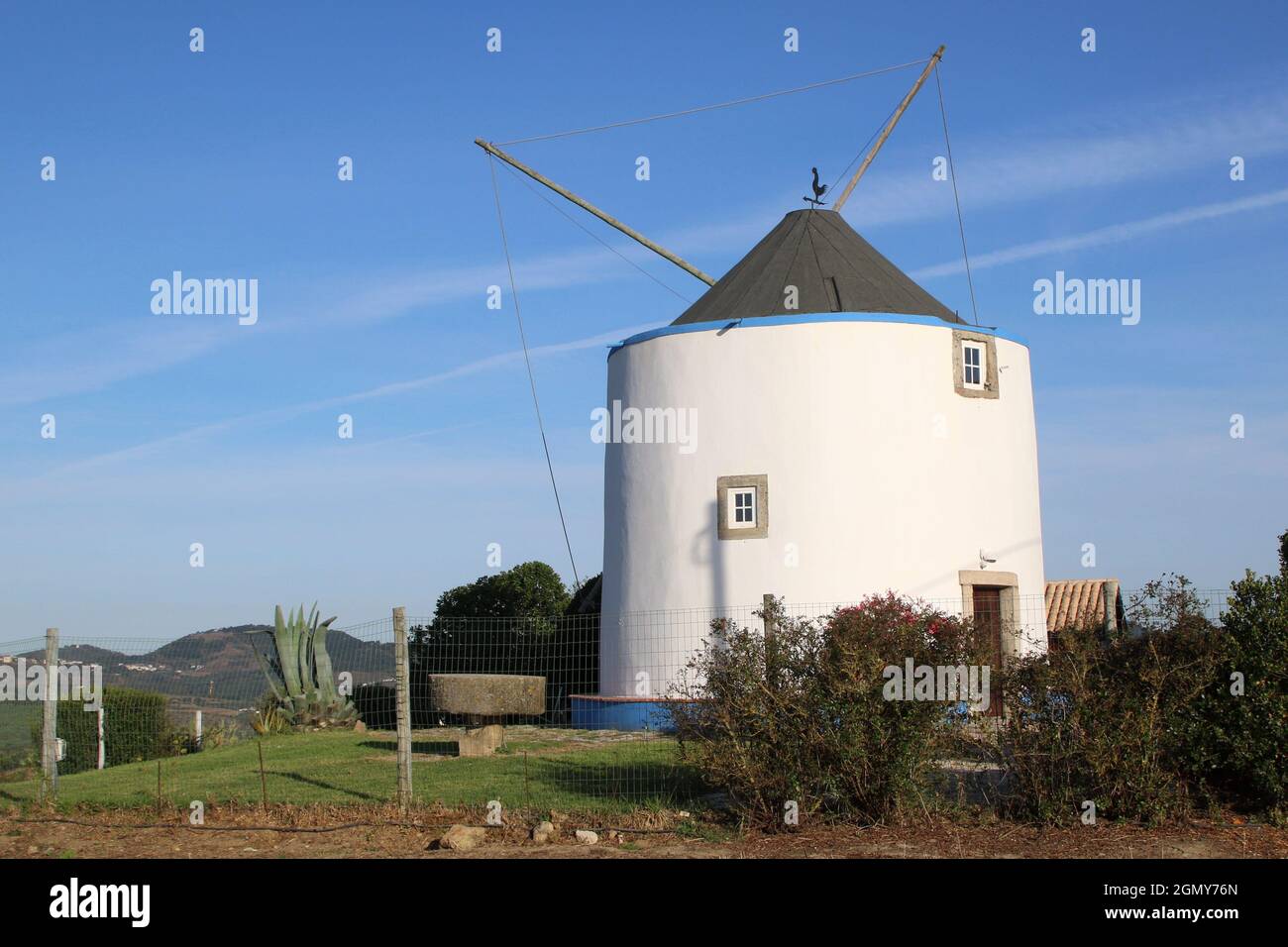 Old traditional windmill under a blue sky in Portugal Stock Photo - Alamy