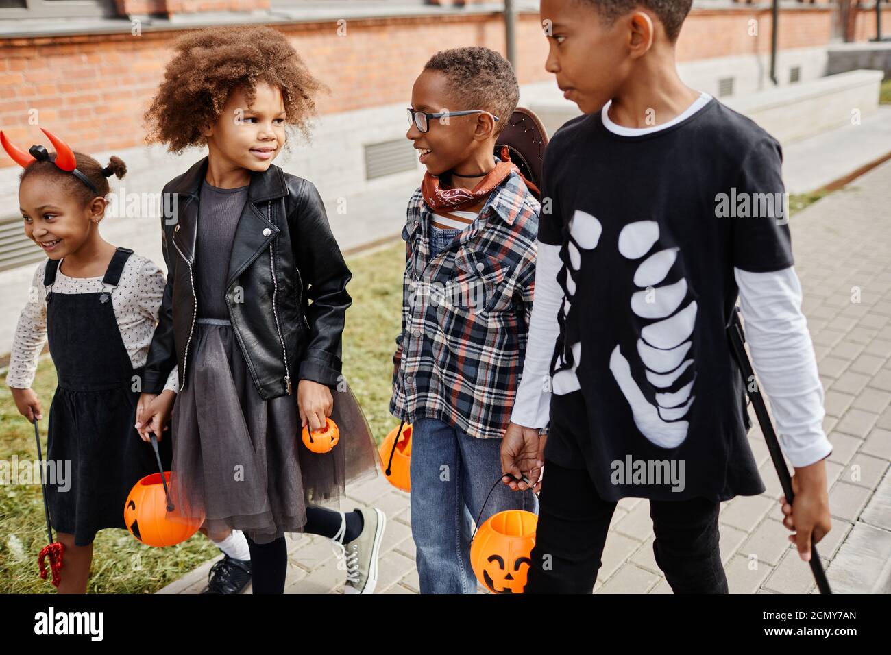 Group of excited African-American kids wearing Halloween costumes ...
