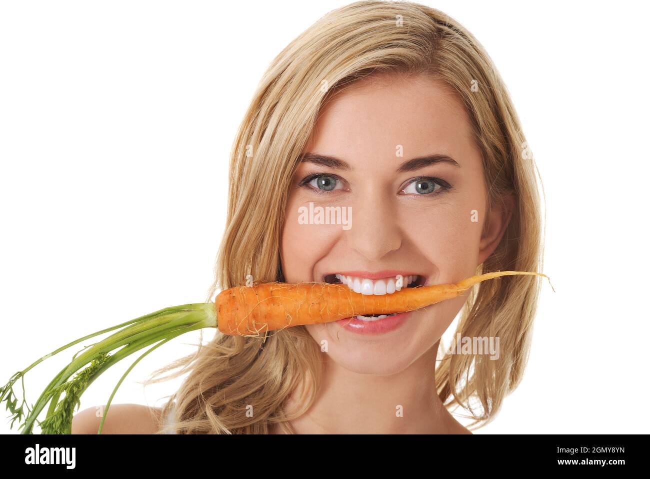 Vertical shot of a Polish woman biting a carrot isolated on white ...