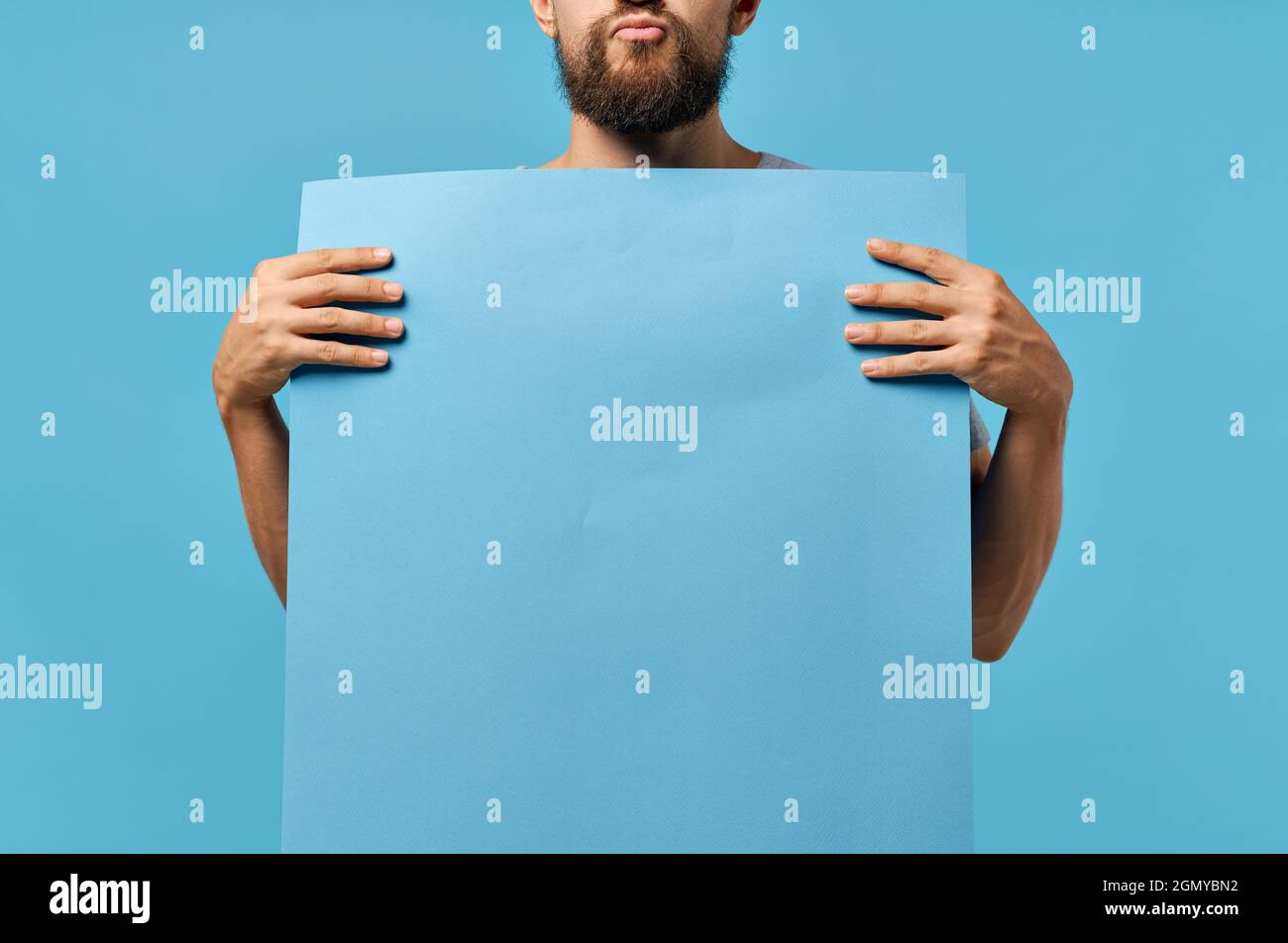 handsome man blue banner in hand blank sheet blue background Stock ...