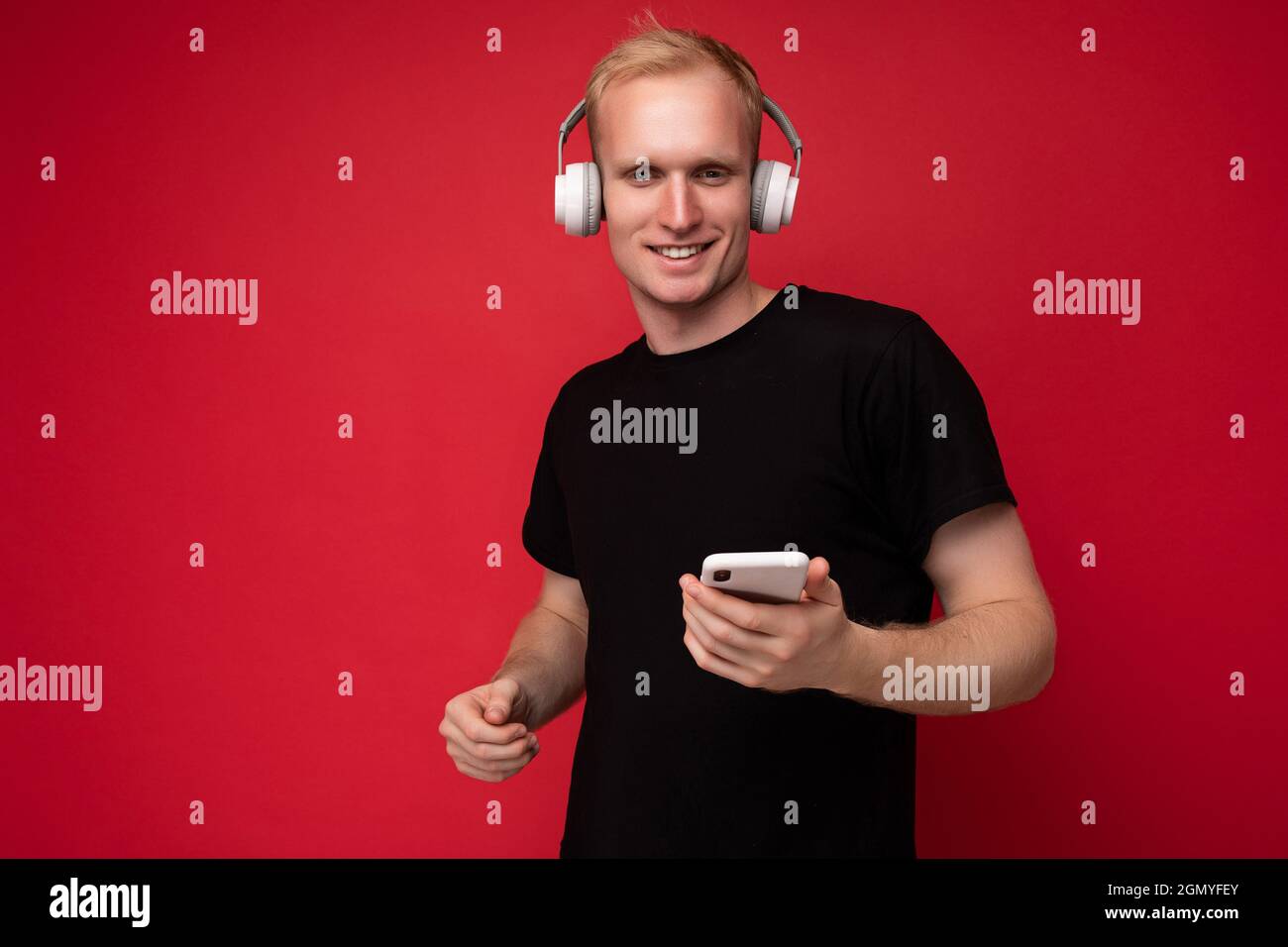 Positive delightful handsome blonde young man wearing black t-shirt and ...