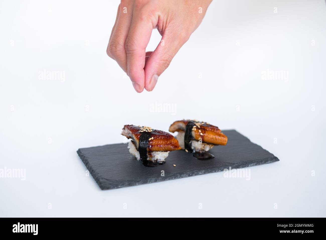 Japanese Sushi - Two Unagi Nigiri Sushi served on a black stone board. Eel Sushi. Isolated on ...