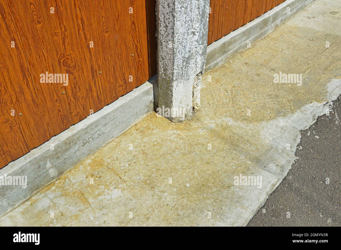 The hexagonal concrete column is concreted in the sidewalk near a metal ...