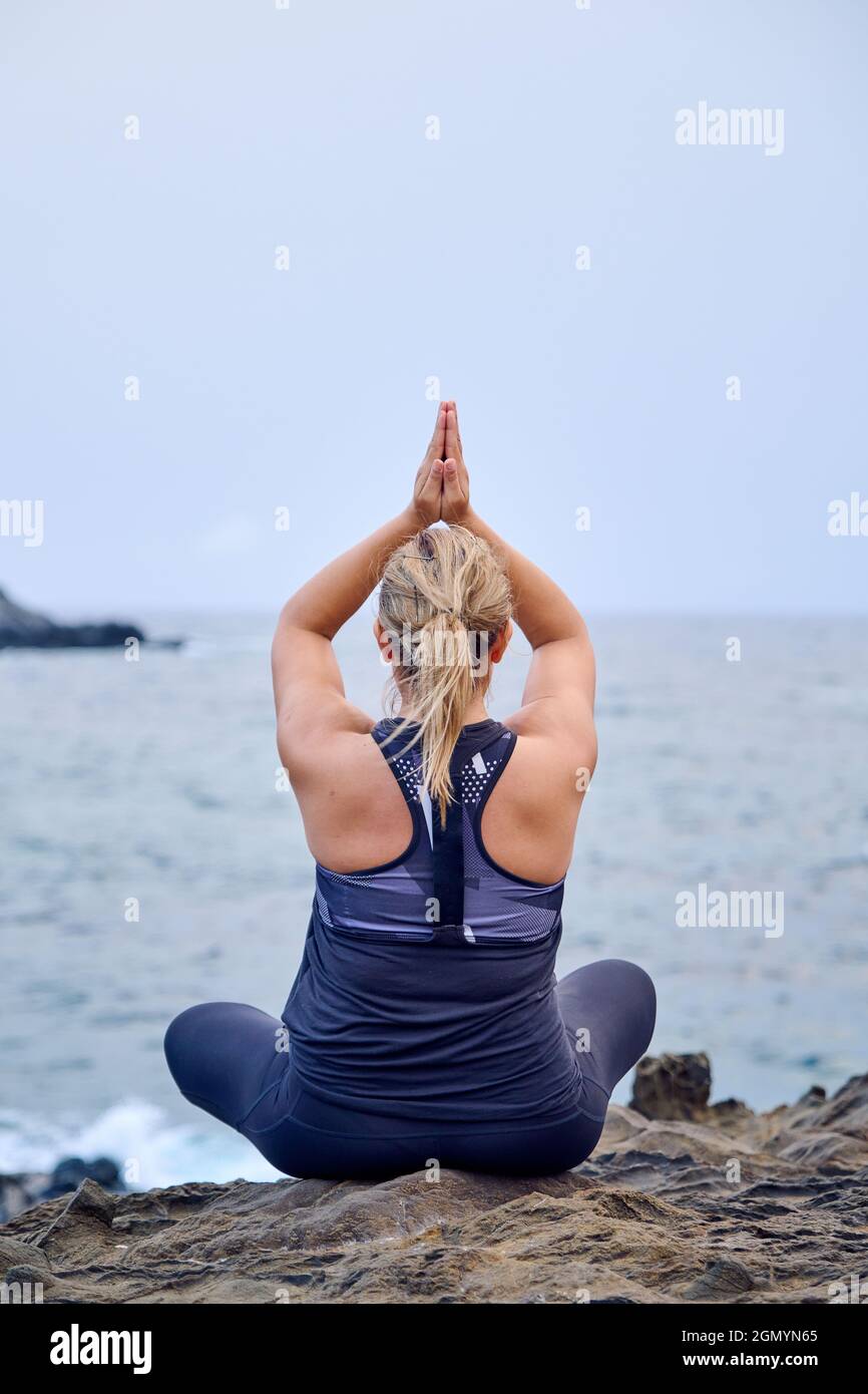 Vertical shot of a Native American woman from Spain practicing yoga at ...