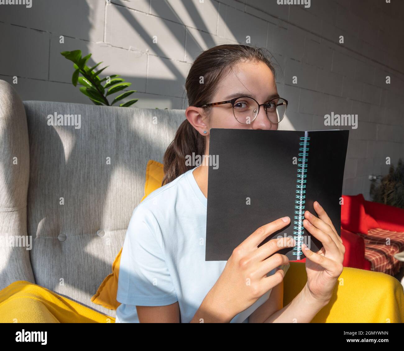 Beautiful girl student reading a book while sitting on an armchair in a ...