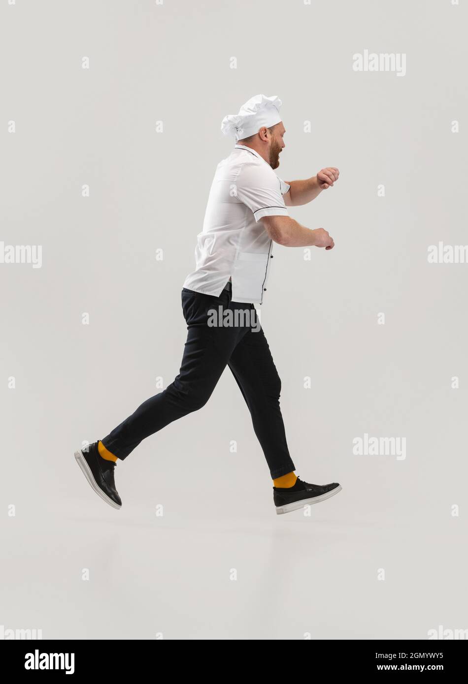 Portrait of cook, chef man in uniform running to kitchen isolated on ...