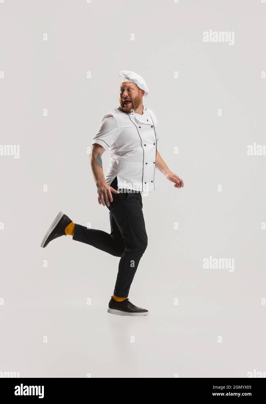 Portrait of cook, chef man in uniform running to kitchen isolated on ...