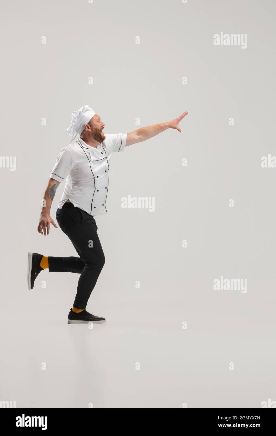 Portrait of cook, chef man in uniform running to kitchen isolated on ...