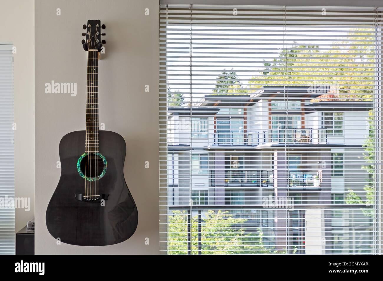 Living room window with guitar on the wall Stock Photo - Alamy