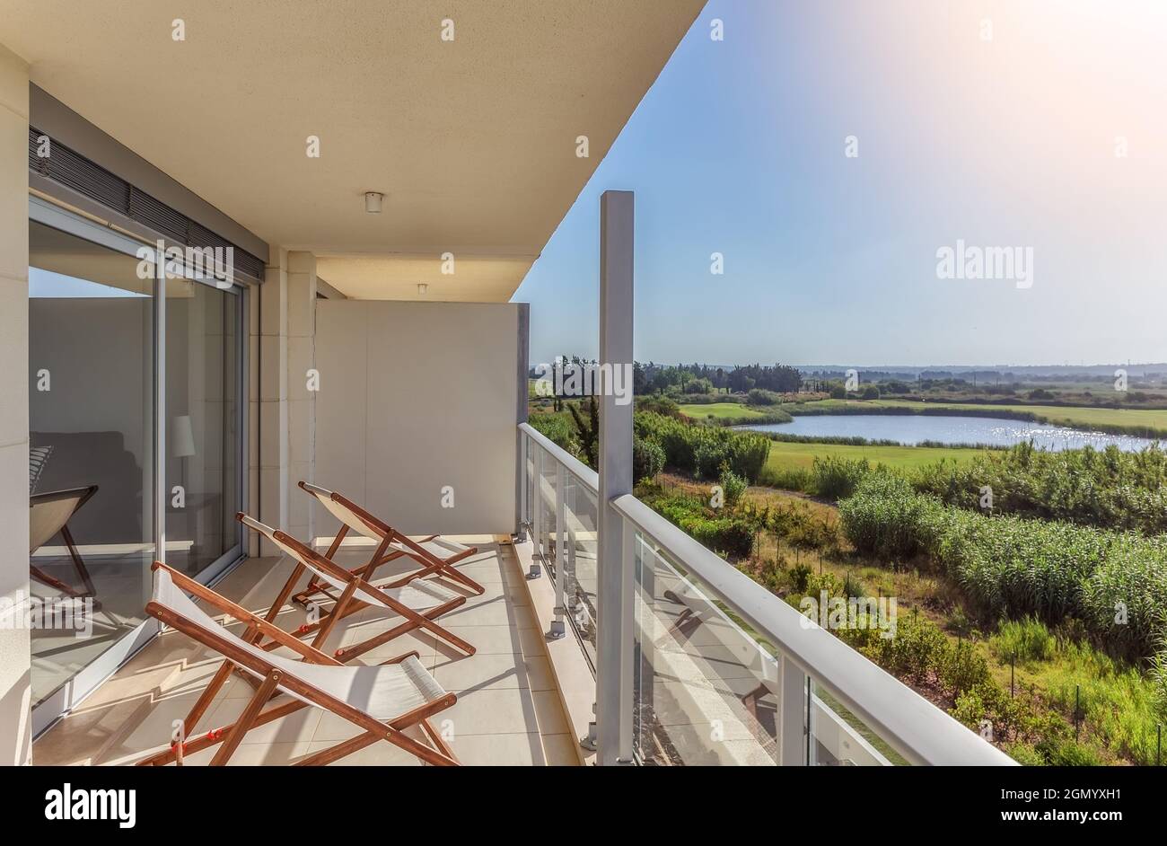 Balcony terrace, overlooking the lake and park, with wooden deck chairs ...