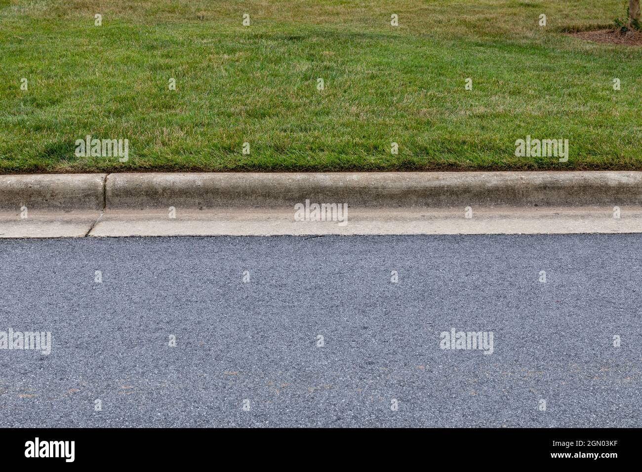 Carefully edged grass alongside extruded concrete curbing and asphalt ...