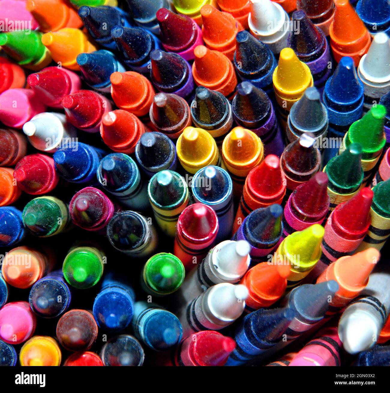 Bunch of new crayons stand on end in a multi-colored background image ...