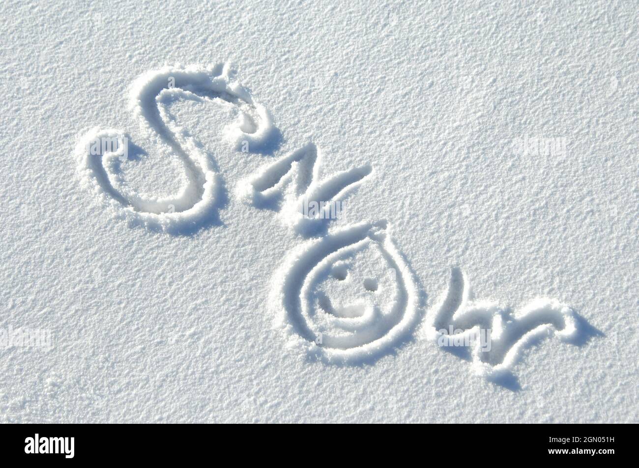 The word "snow" is handwritten on a fresh layer of snow. Smiley face ...