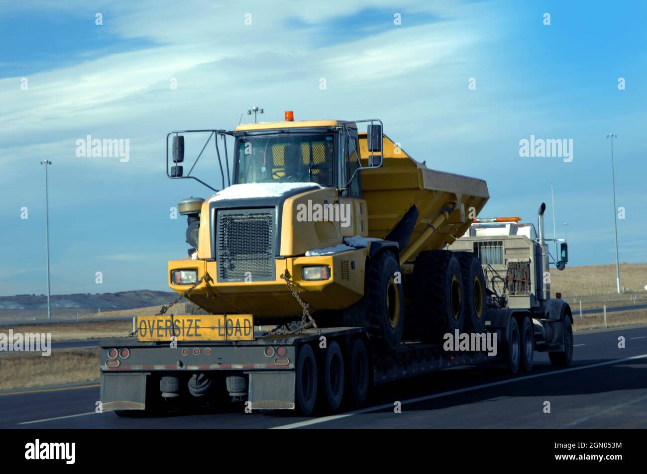 Eighteen wheeler hauls a heavy, oversized dump truck down the ...