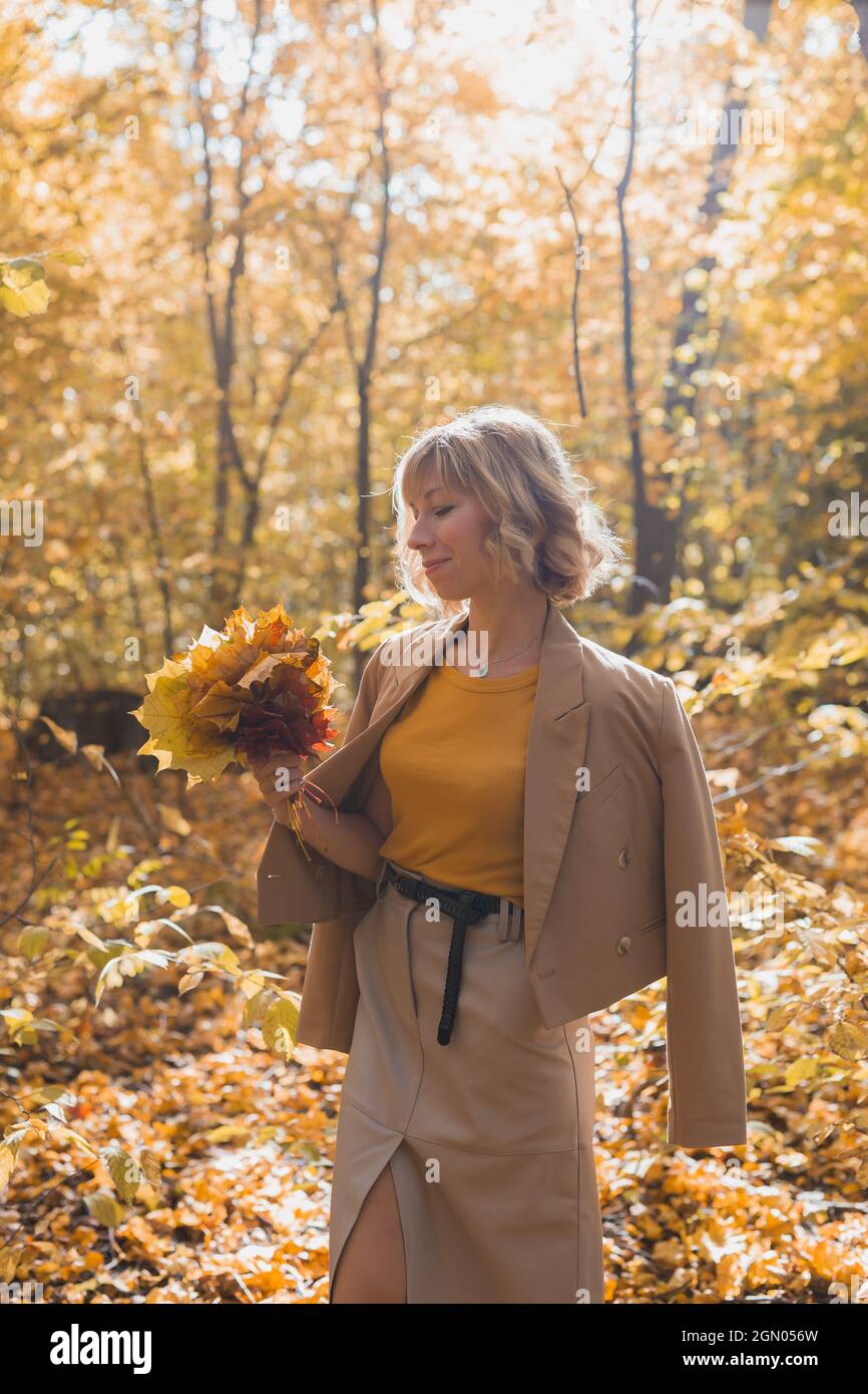 Portrait of beautiful young woman walking outdoors in autumn. Fall ...